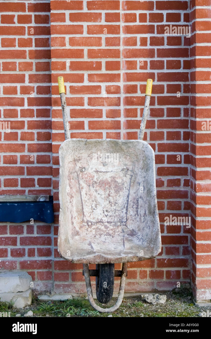 Wheelbarrow against brick wall on building site in UK Stock Photo - Alamy