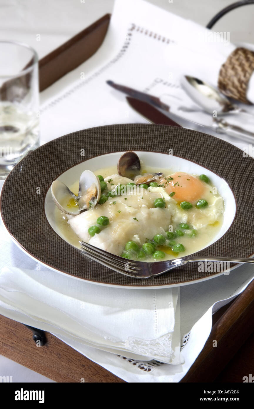 Hake in parsley sauce with clams peas and poached egg Stock Photo - Alamy