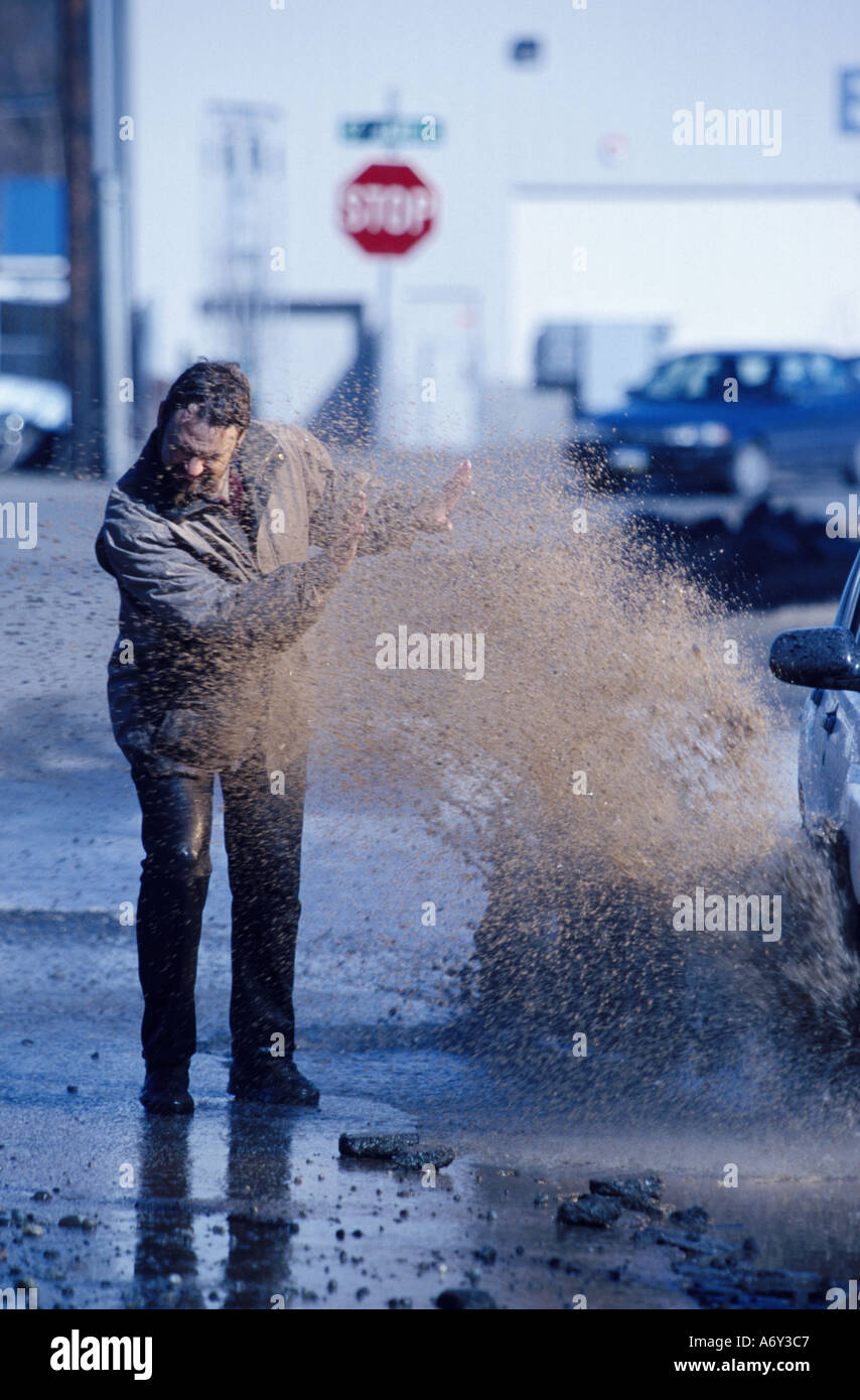 Car splashes man alongside road Southcentral Alaska spring portrait ...