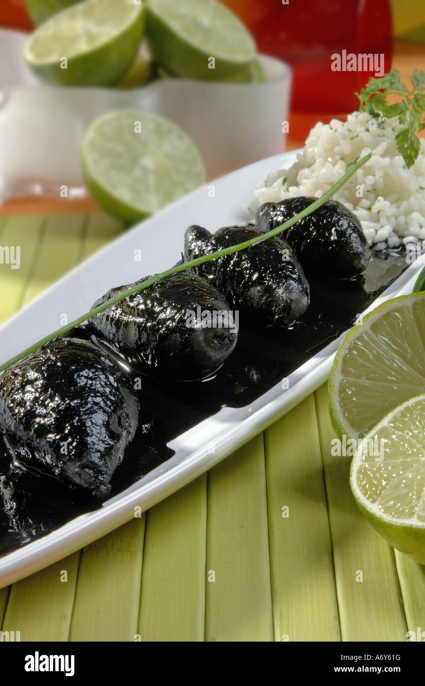 Stuffed baby squid in ink sauce with rice Stock Photo - Alamy