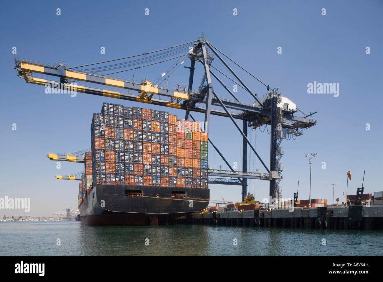 Container ship below cranes at a commercial dock Stock Photo - Alamy
