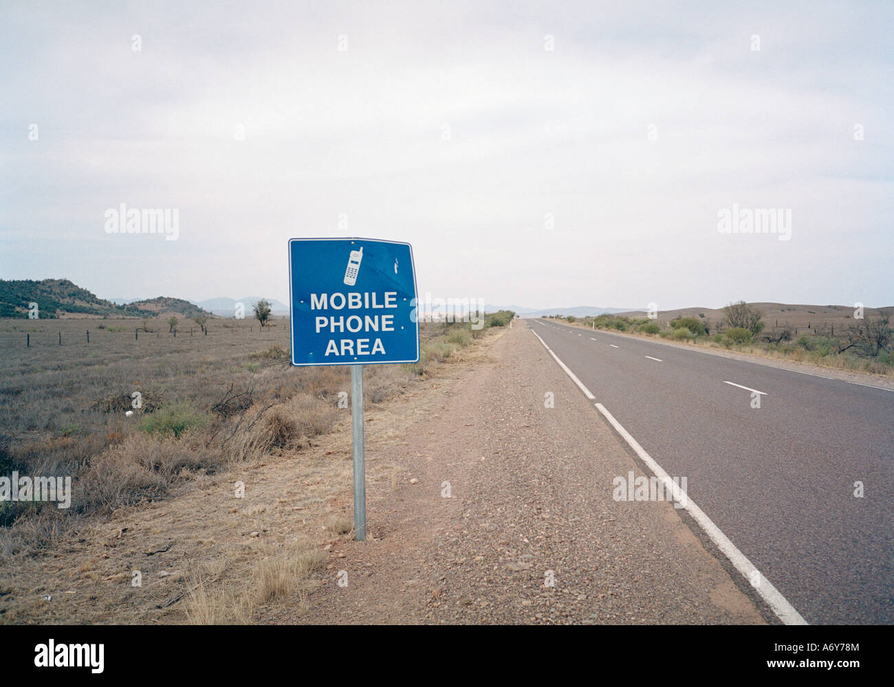 Mobile phone area road sign next to a two lane highway Stock Photo - Alamy