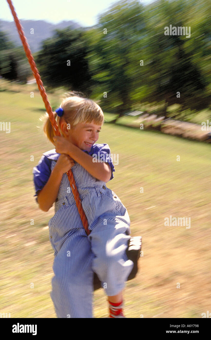 portrait of a girl swinging on a rope Stock Photo - Alamy