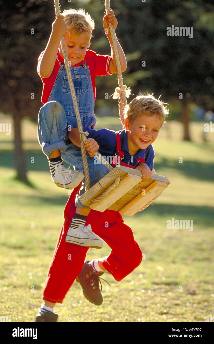 portrait of twin brothers playing on a swing Stock Photo - Alamy