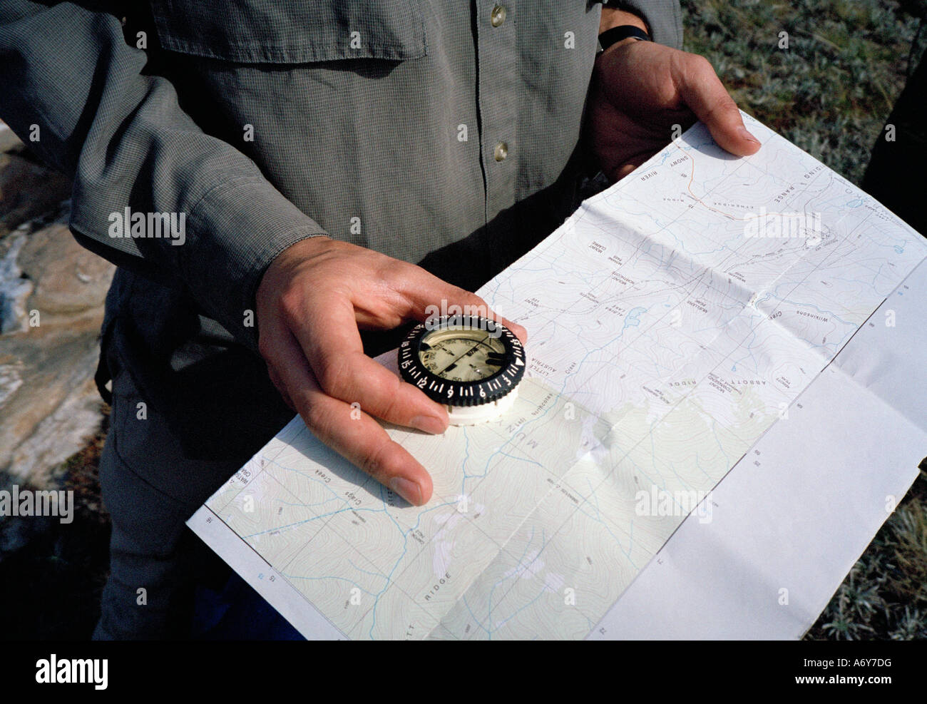 Man holding a compass on a map Stock Photo - Alamy