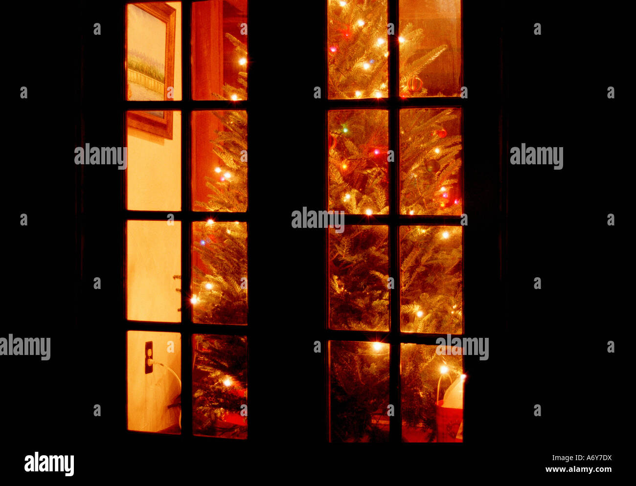 Illuminated Christmas tree seen through a window Stock Photo - Alamy