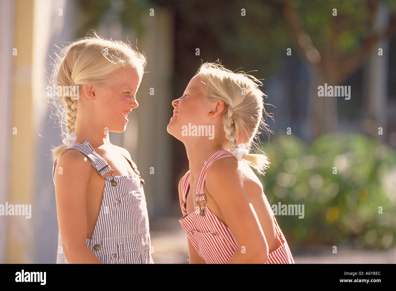 portrait of twin sisters talking to each other Stock Photo - Alamy