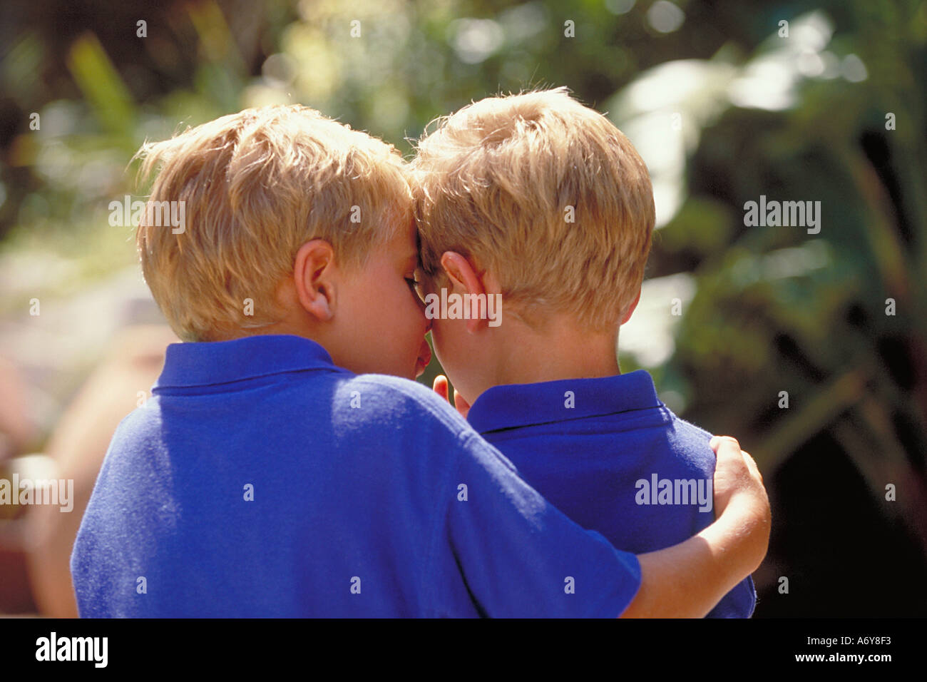 portrait of twin brothers whispering secrets Stock Photo - Alamy