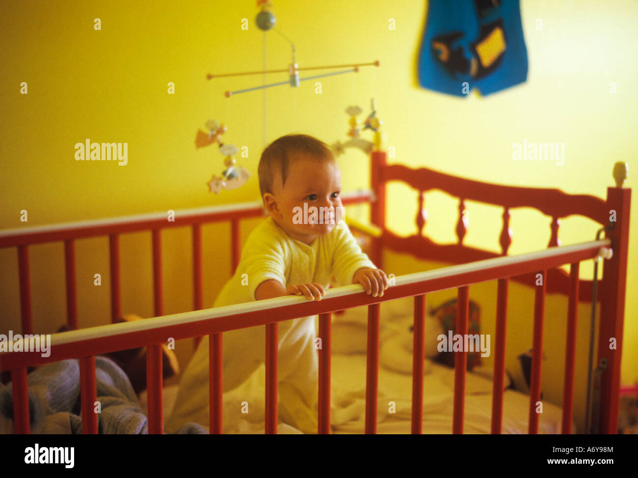 Baby boy standing up in his crib Stock Photo - Alamy