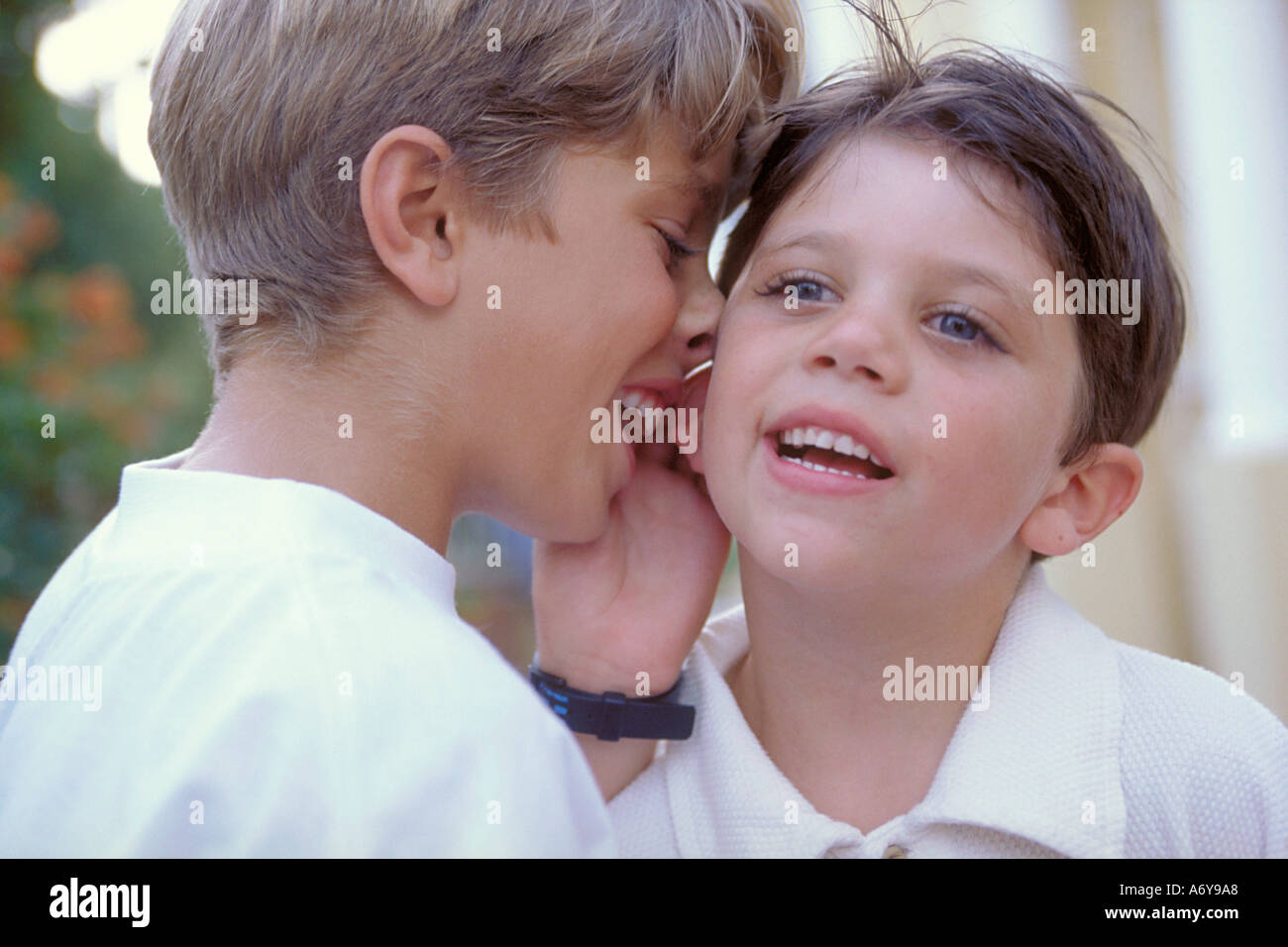 portrait of two boys whispering a secret Stock Photo - Alamy