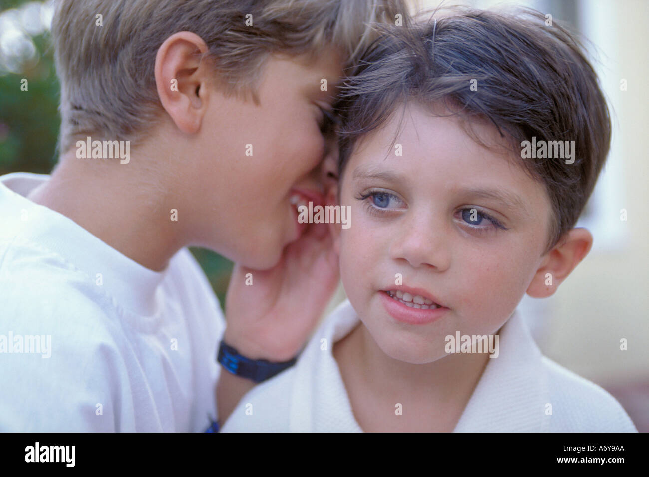 portrait of two boys whispering a secret Stock Photo - Alamy
