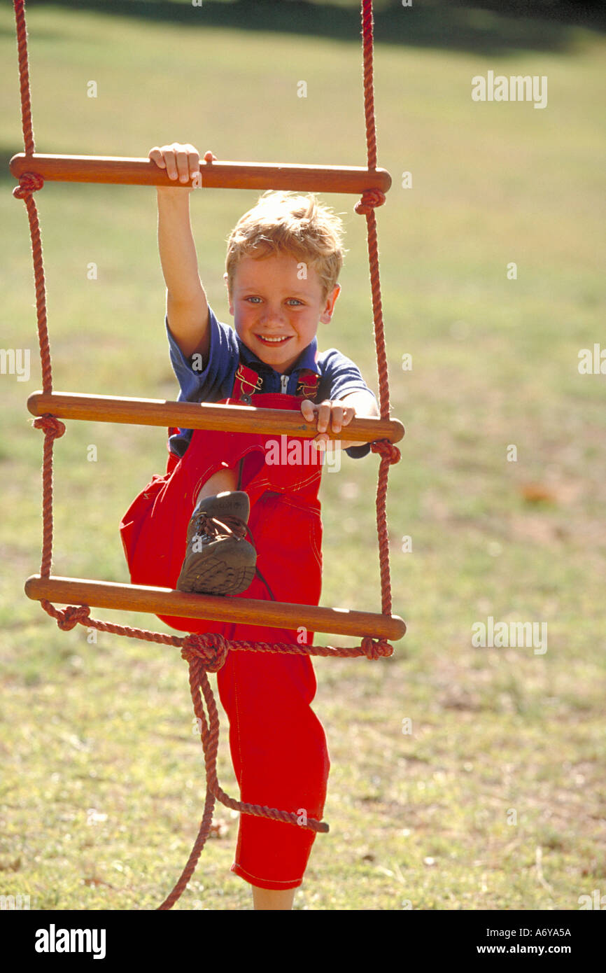 portrait of boy climbing a ladder Stock Photo - Alamy
