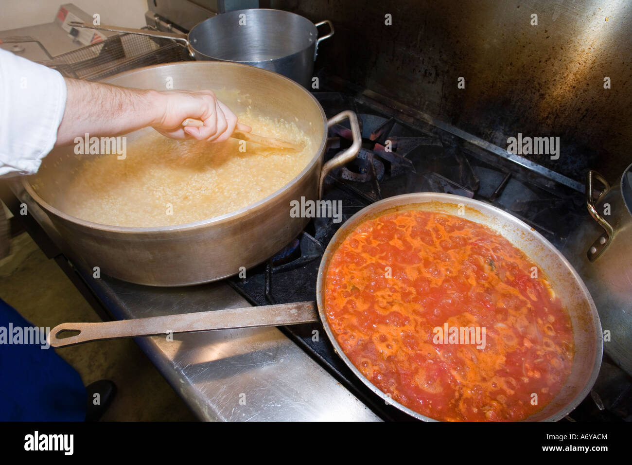 Chef stirring pots of food cooking on a stove Stock Photo - Alamy