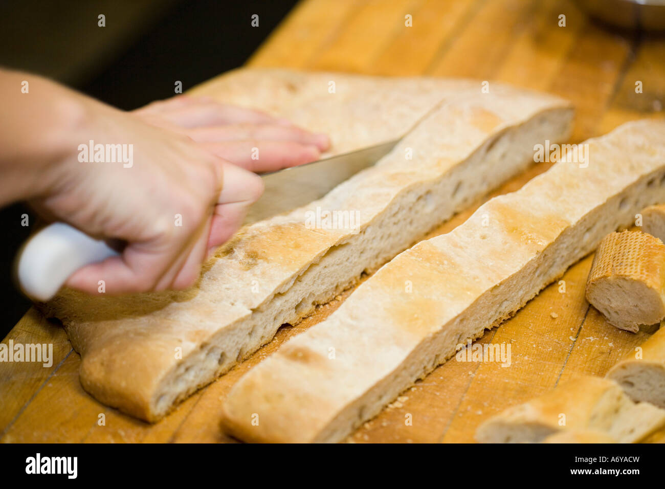 Person slicing bread on a cutting board Stock Photo - Alamy