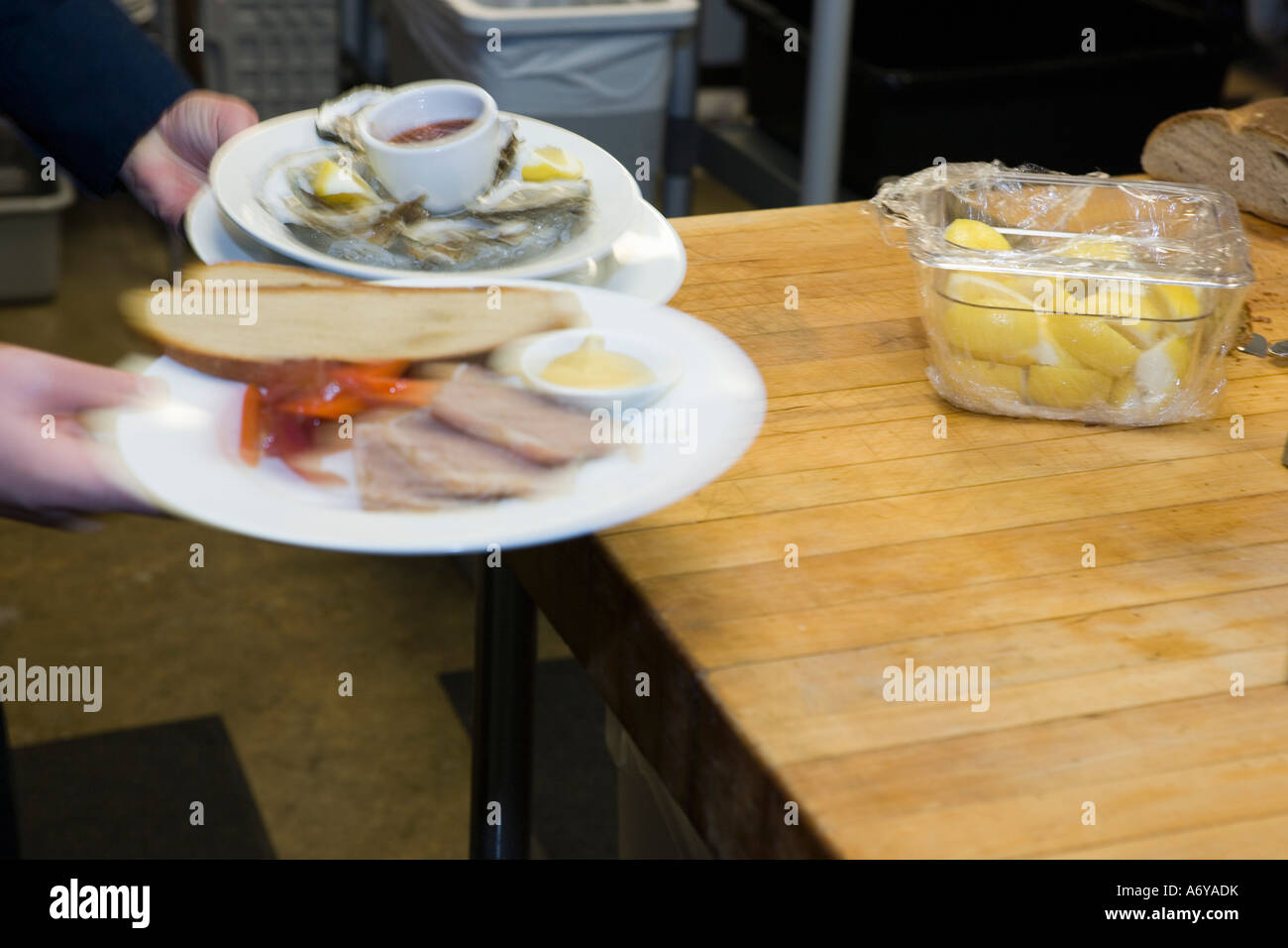 Waiter picking up plates of food from a restaurant kitchen Stock Photo ...