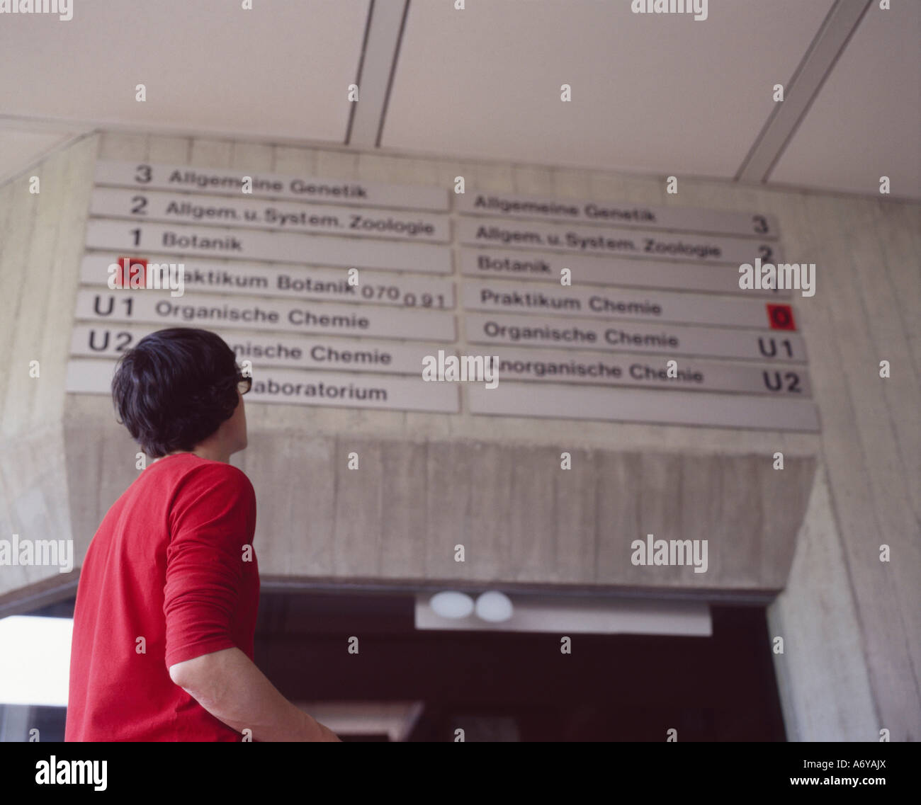 University student looking at the information signs in the foyer of a ...