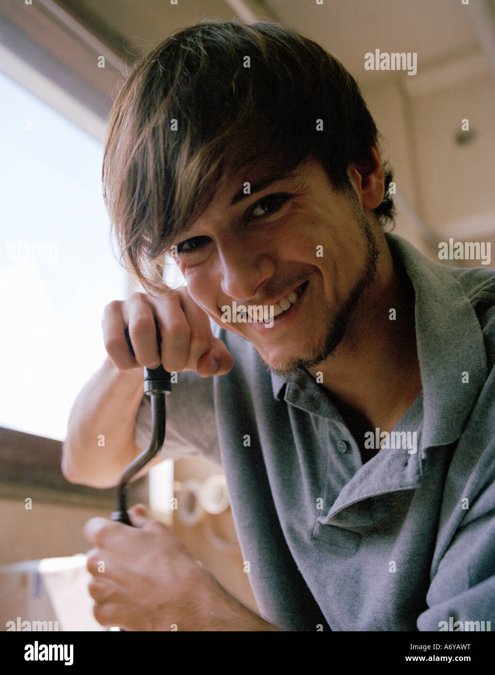 Portrait of a man using a hand drill in a workshop Stock Photo - Alamy