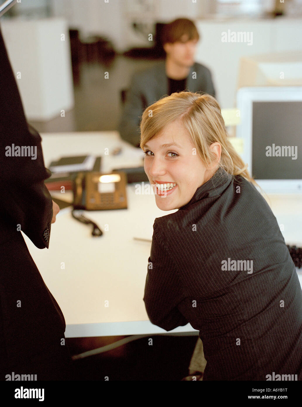 Young woman looking over her shoulder whilst in a stylish office Stock ...