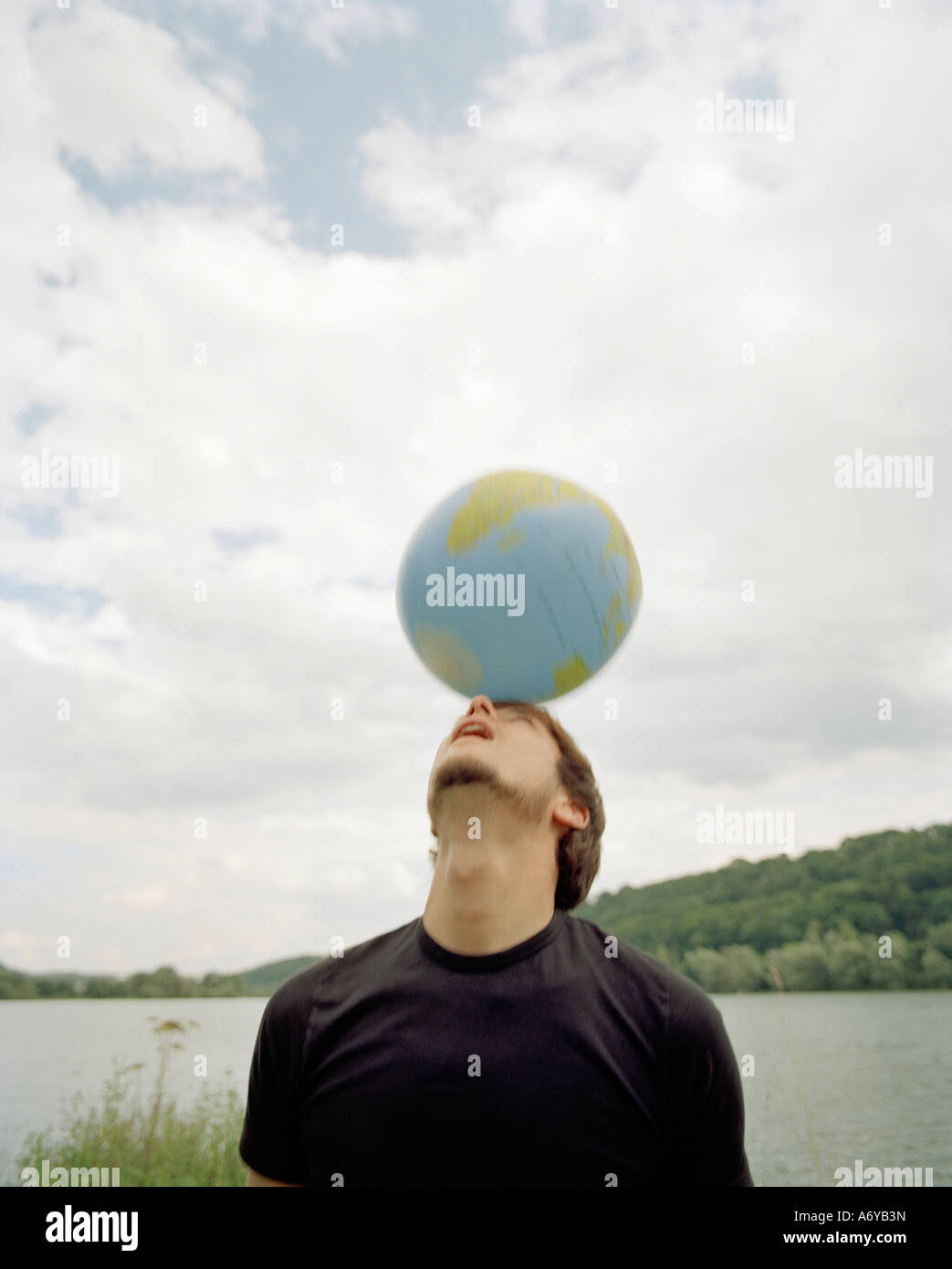 A young man balancing a ball on his head Stock Photo - Alamy