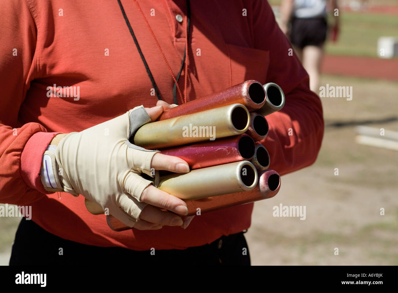 Man holding a bundle of relay batons Stock Photo - Alamy
