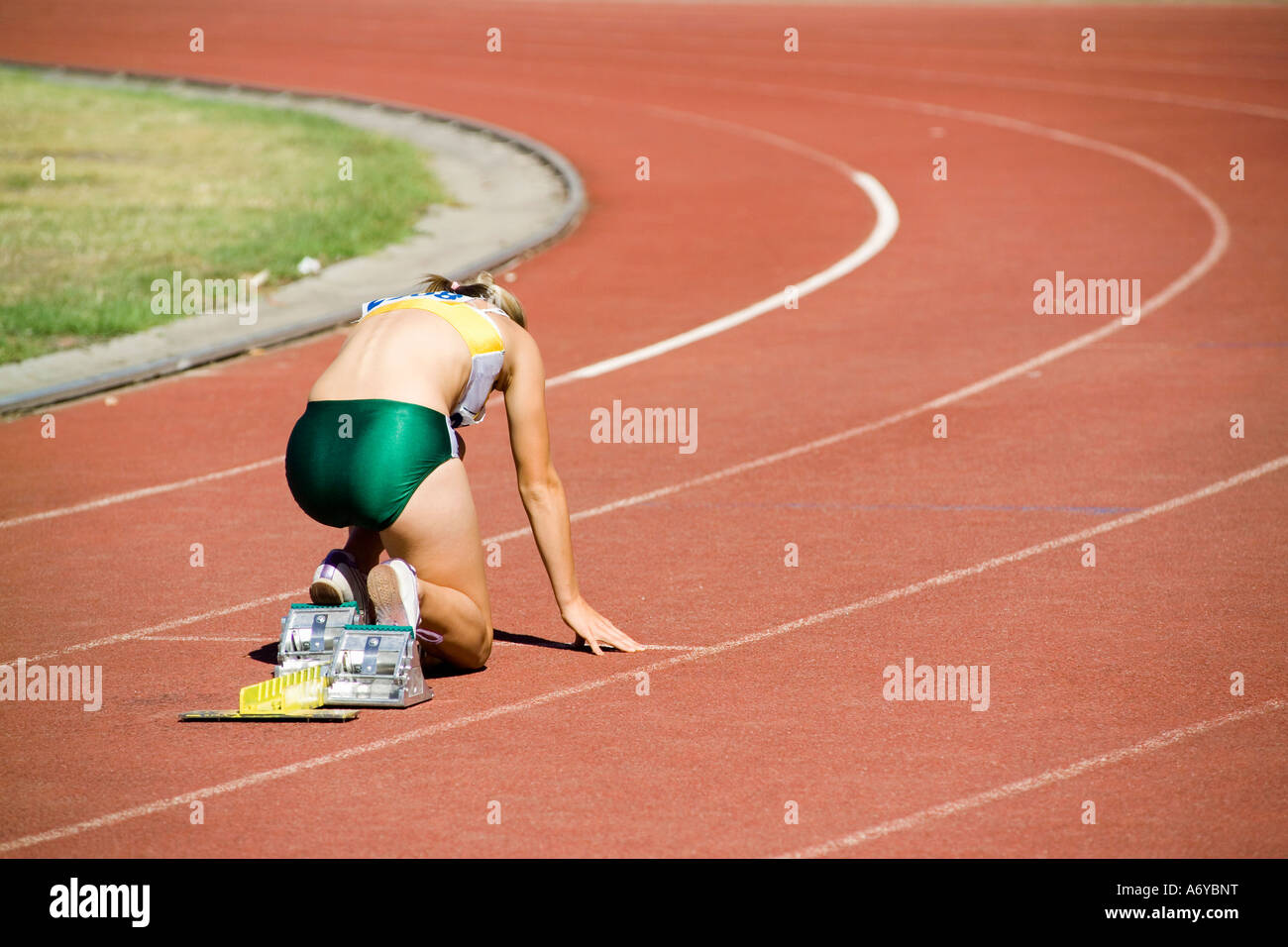 Female athlete in starting blocks on a running track Stock Photo - Alamy