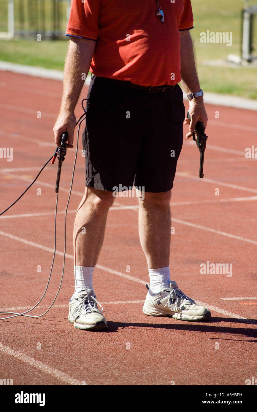Man on a running track and holding a starting gun Stock Photo - Alamy