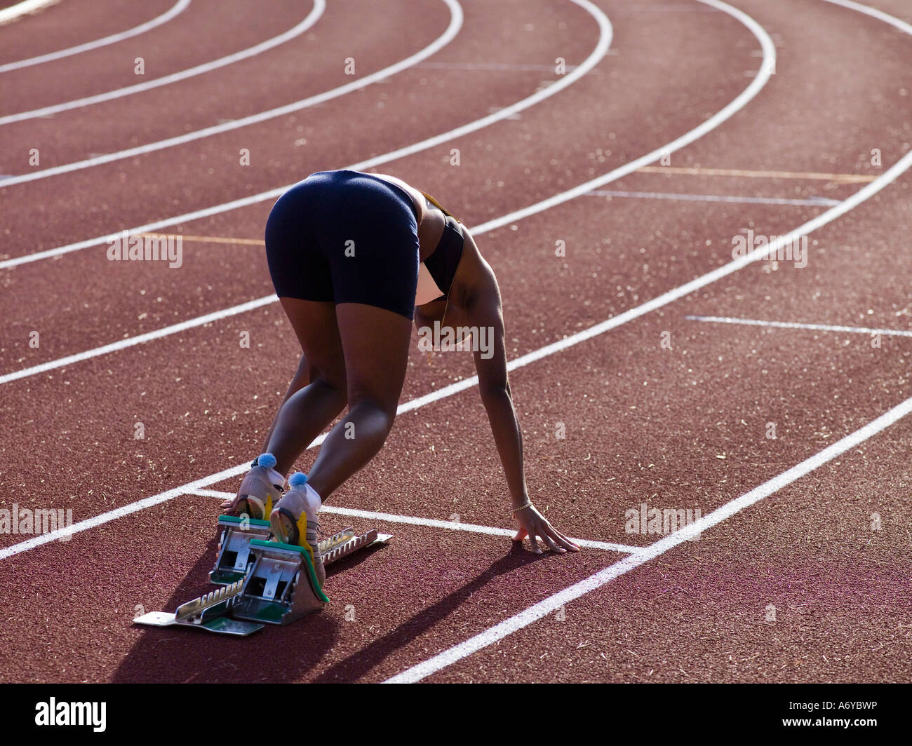 Female athlete in starting blocks on a running track Stock Photo - Alamy