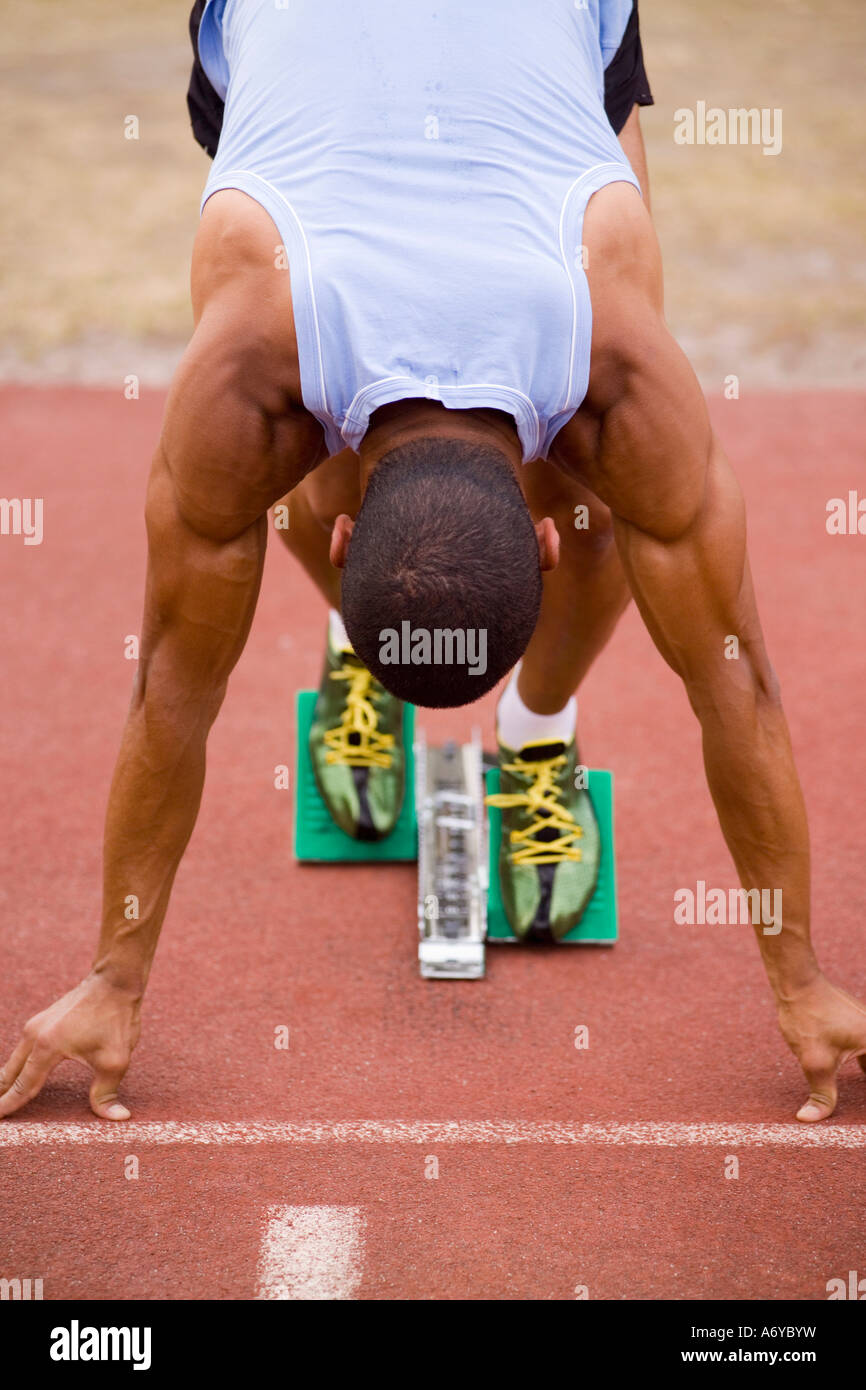 Male athlete in starting blocks on a running track Stock Photo - Alamy