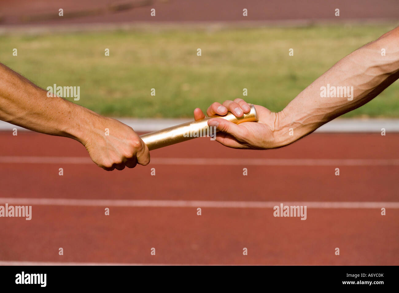 Two athletes exchanging a baton during a relay race Stock Photo - Alamy
