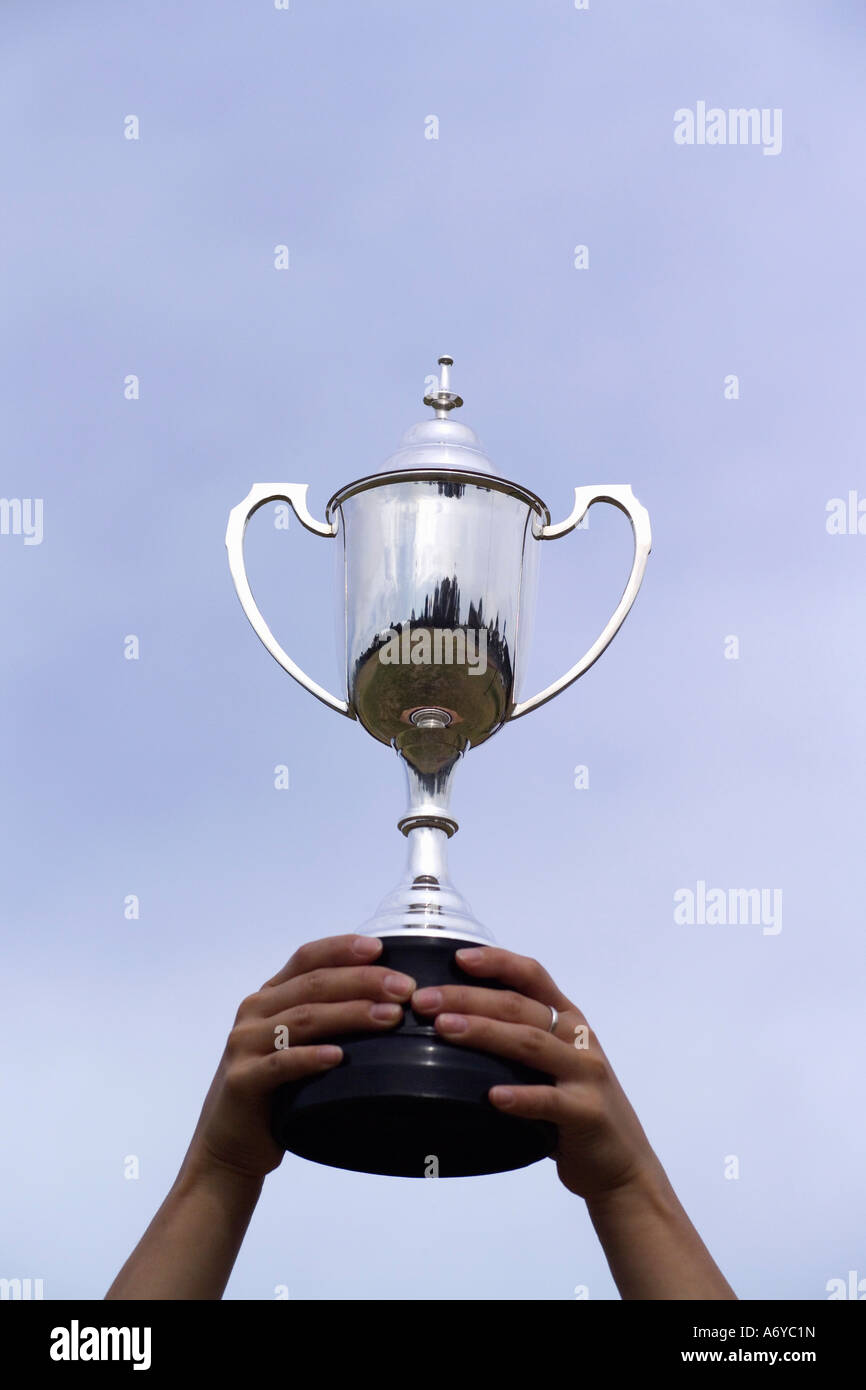 Female athlete holding up a trophy Stock Photo - Alamy