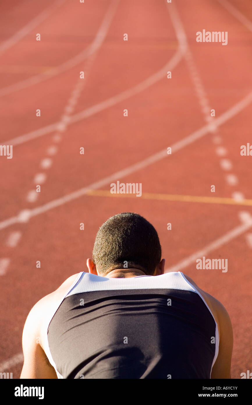 Rear view of a male athlete in starting blocks on a running track Stock ...
