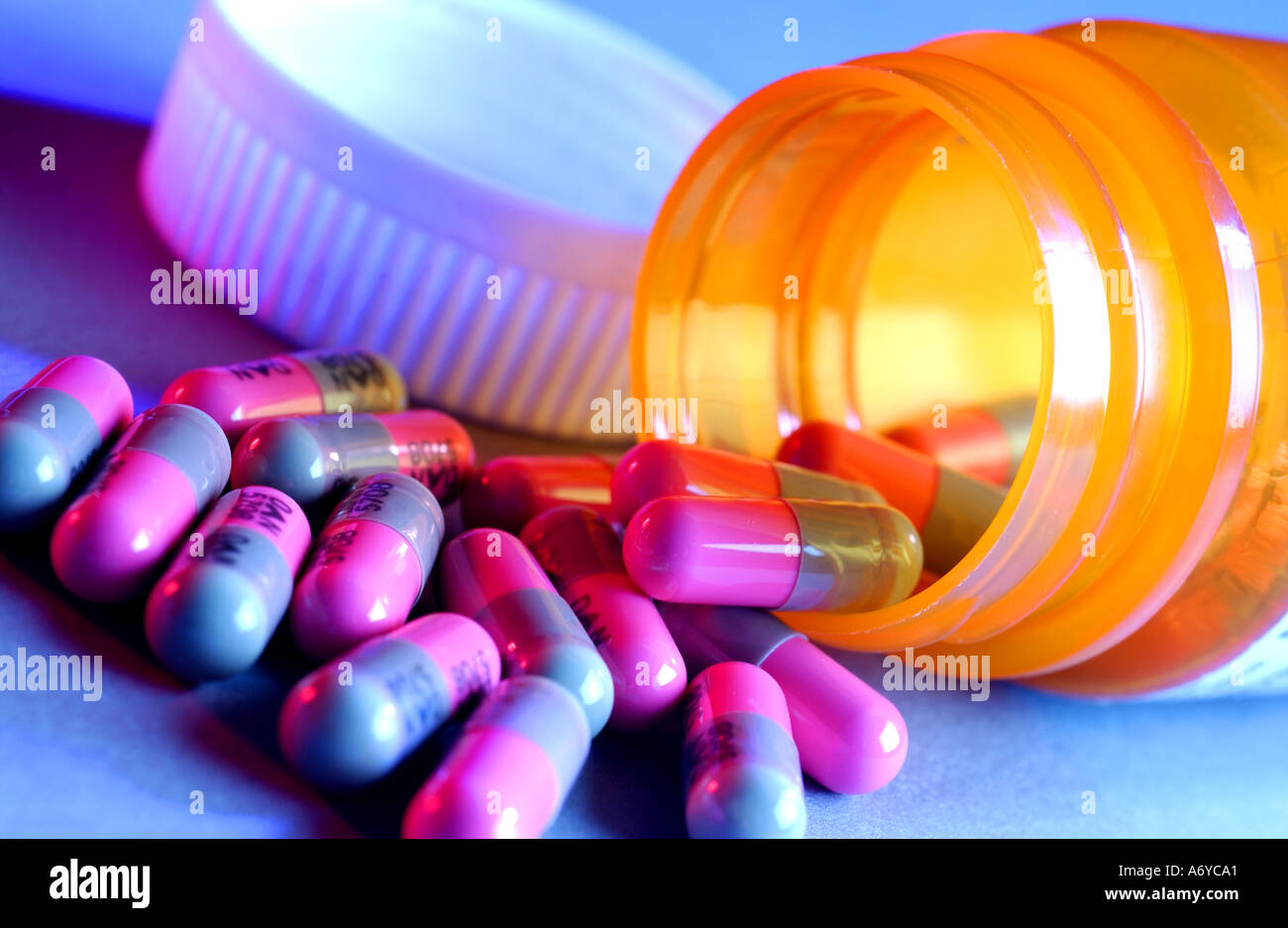 Horizontal color image of capsules pouring from a yellow medicine ...