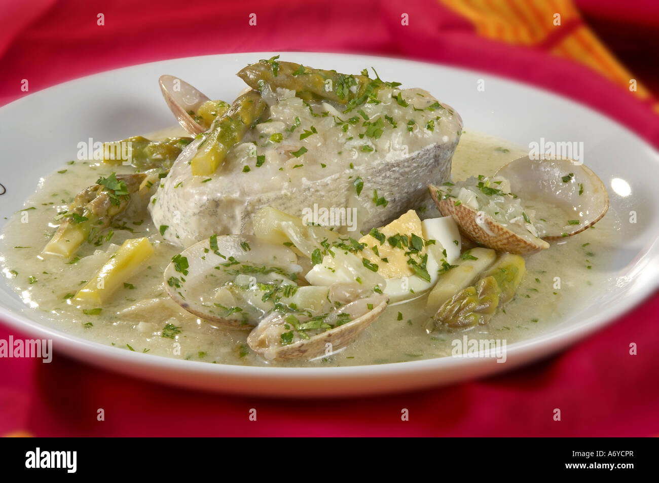 Koskera Basquian style hake with green asparagus Stock Photo - Alamy