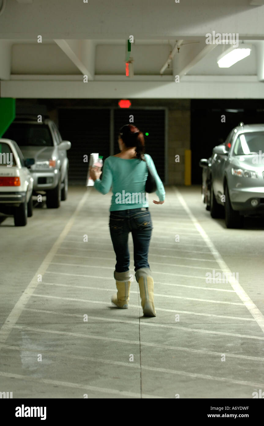 Young woman walking to her car in underground parking garage Stock ...