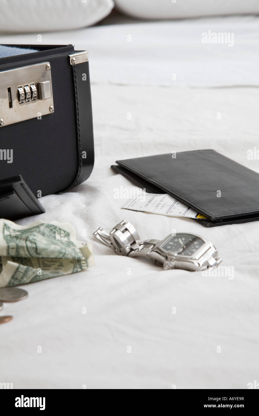 Wallet money a wristwatch and a briefcase on a bed Stock Photo - Alamy