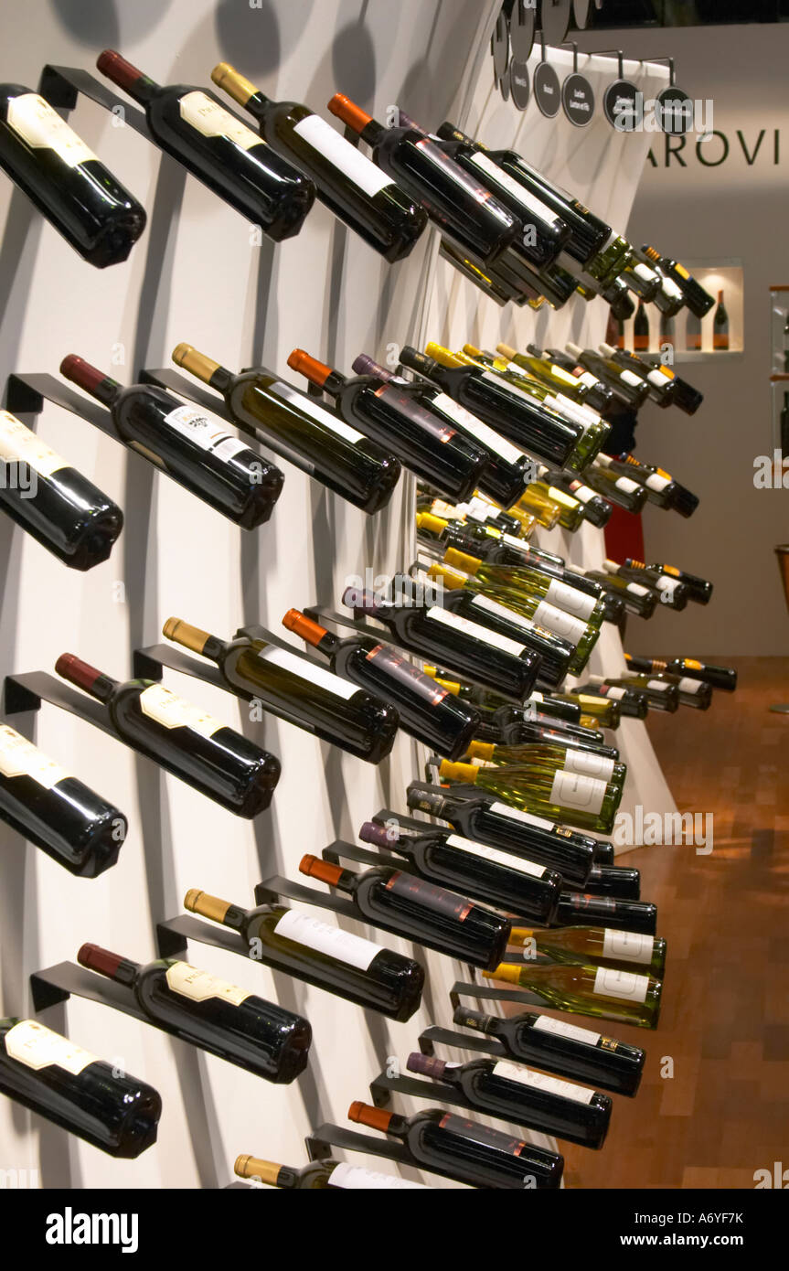 One of the exhibition booths displaying rows of wine bottles in curved ...