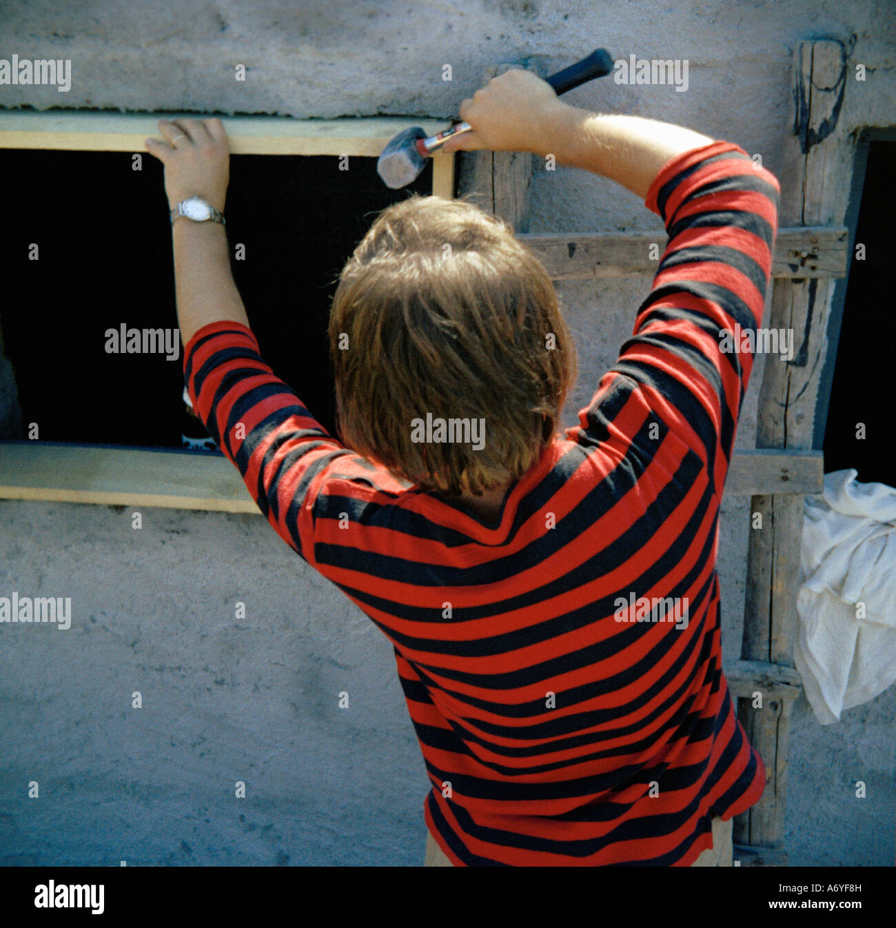 Rear view of man using hammer Stock Photo - Alamy