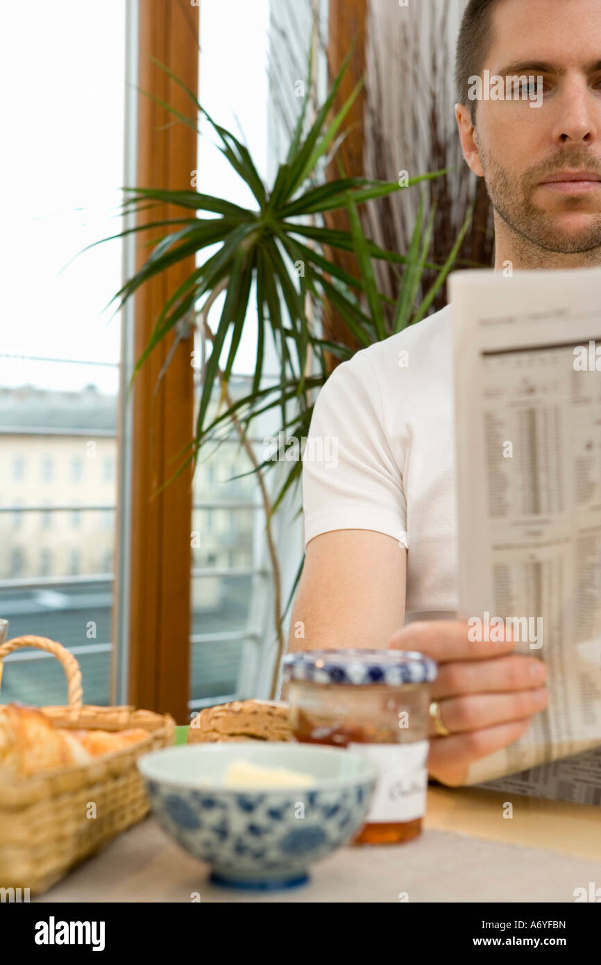 Man reading a newspaper over breakfast Stock Photo - Alamy