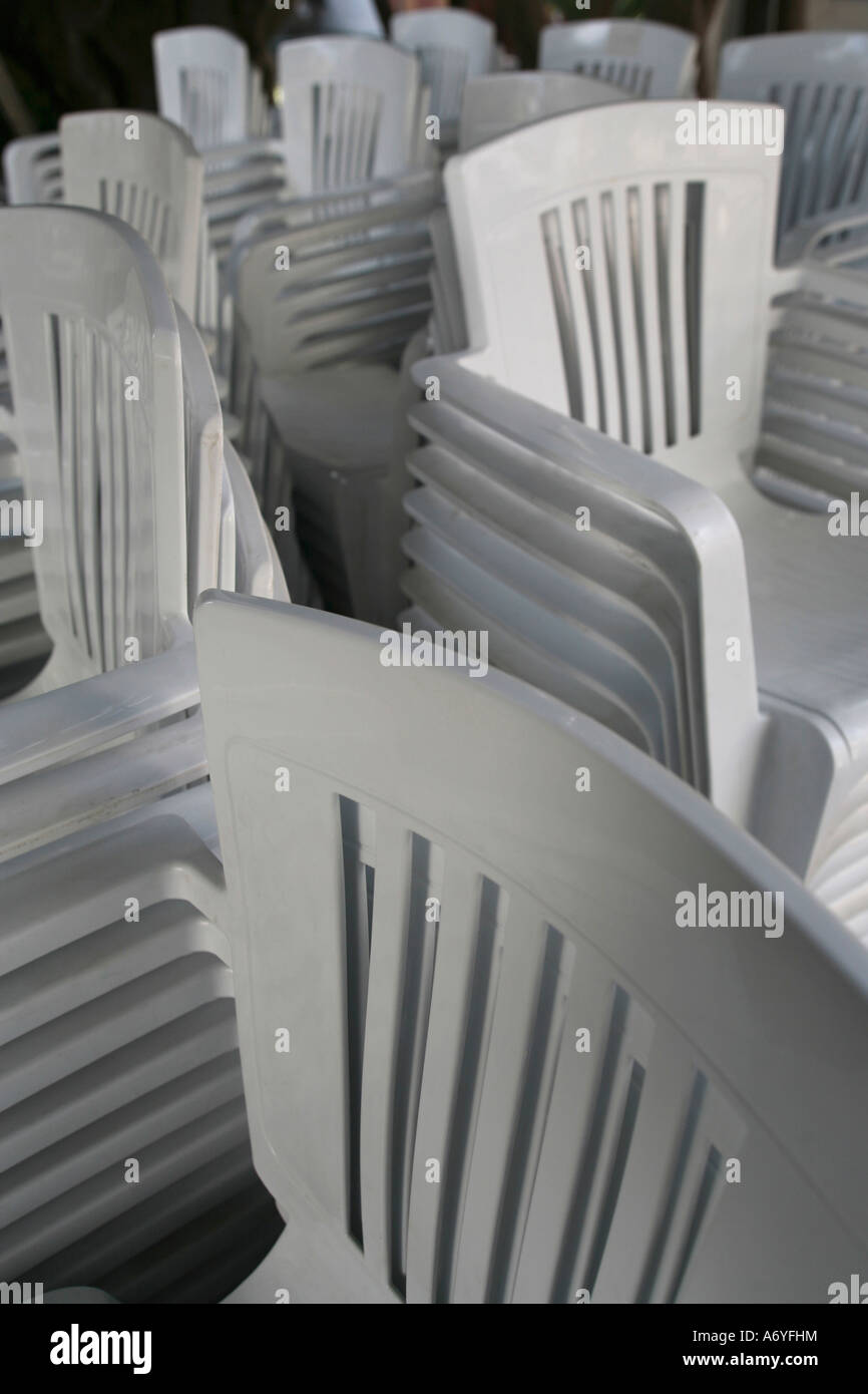 Stacked white plastic chairs Stock Photo - Alamy