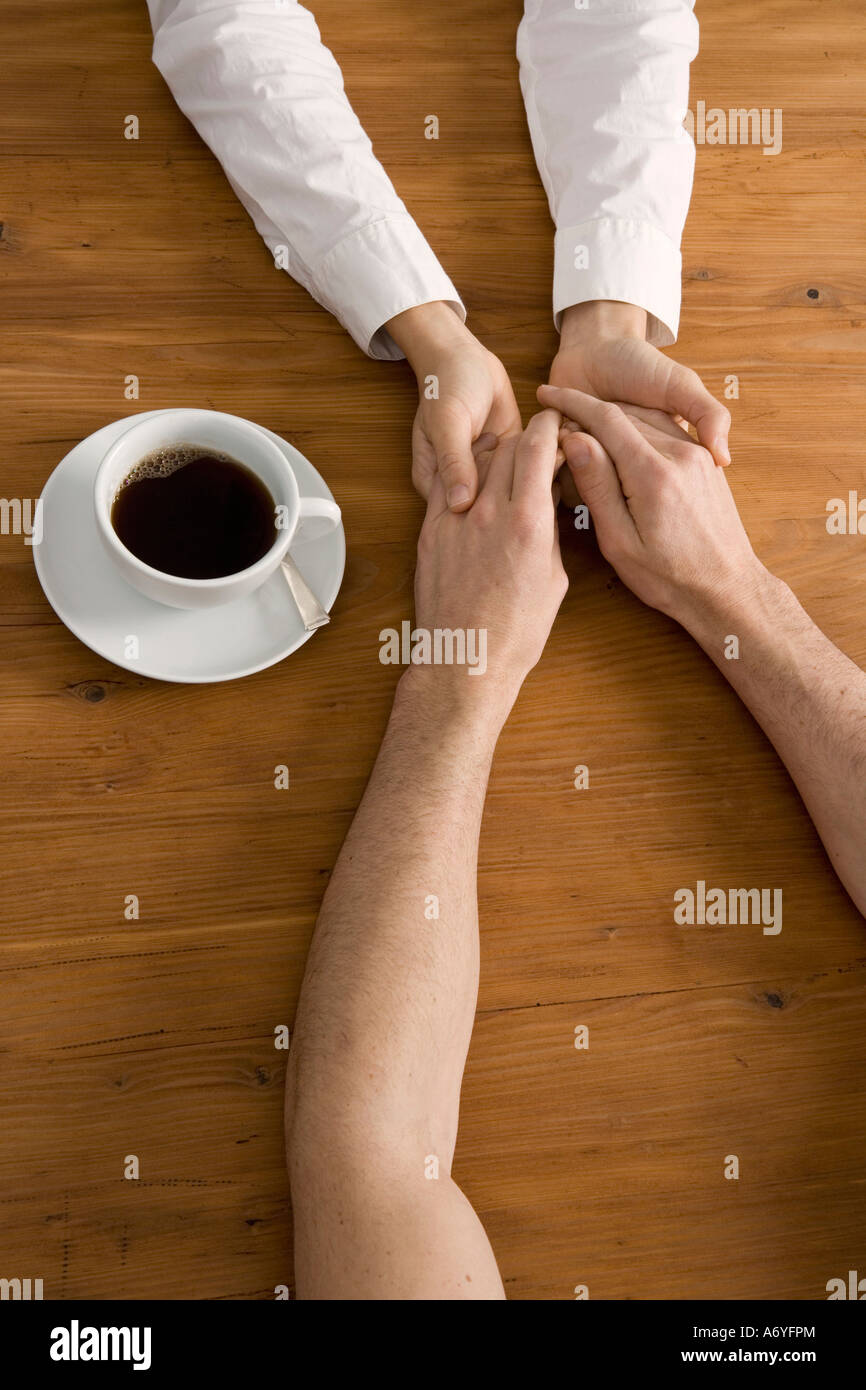 A couple holding hands across a table Stock Photo - Alamy