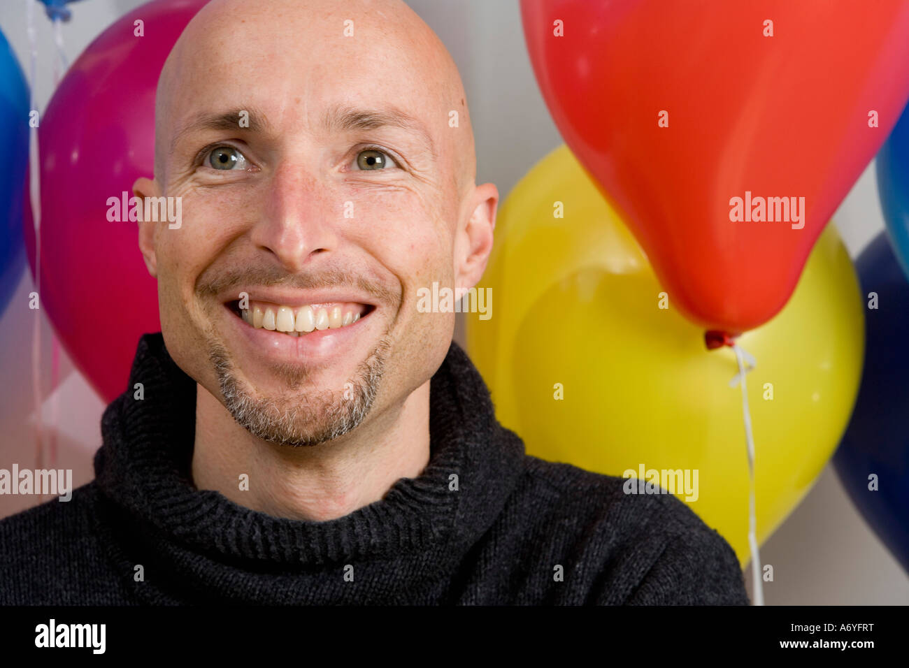 Man sitting in front of balloons Stock Photo - Alamy