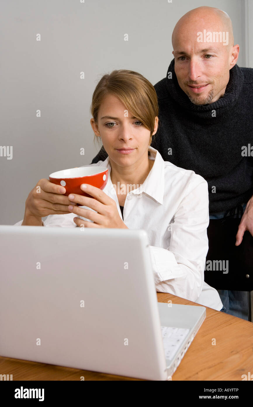 Couple looking at laptop together Stock Photo - Alamy