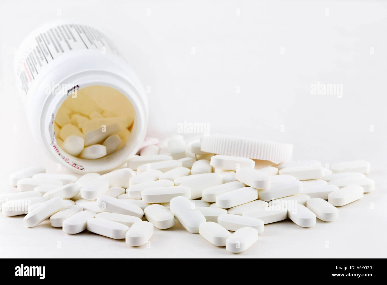 Pills spilling out of an open bottle Stock Photo - Alamy