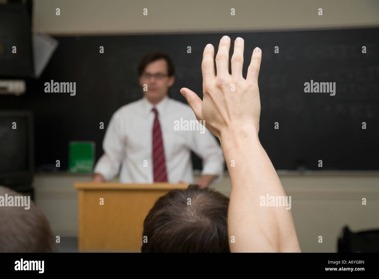 Student with hand raised in lecture room Stock Photo - Alamy