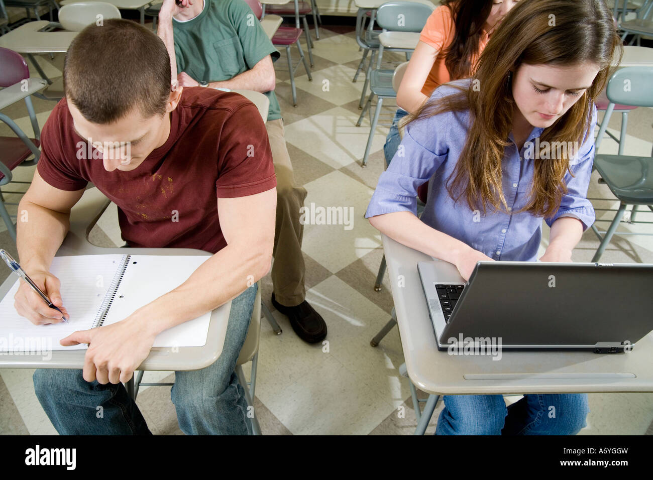 Students sitting at desks and working Stock Photo - Alamy