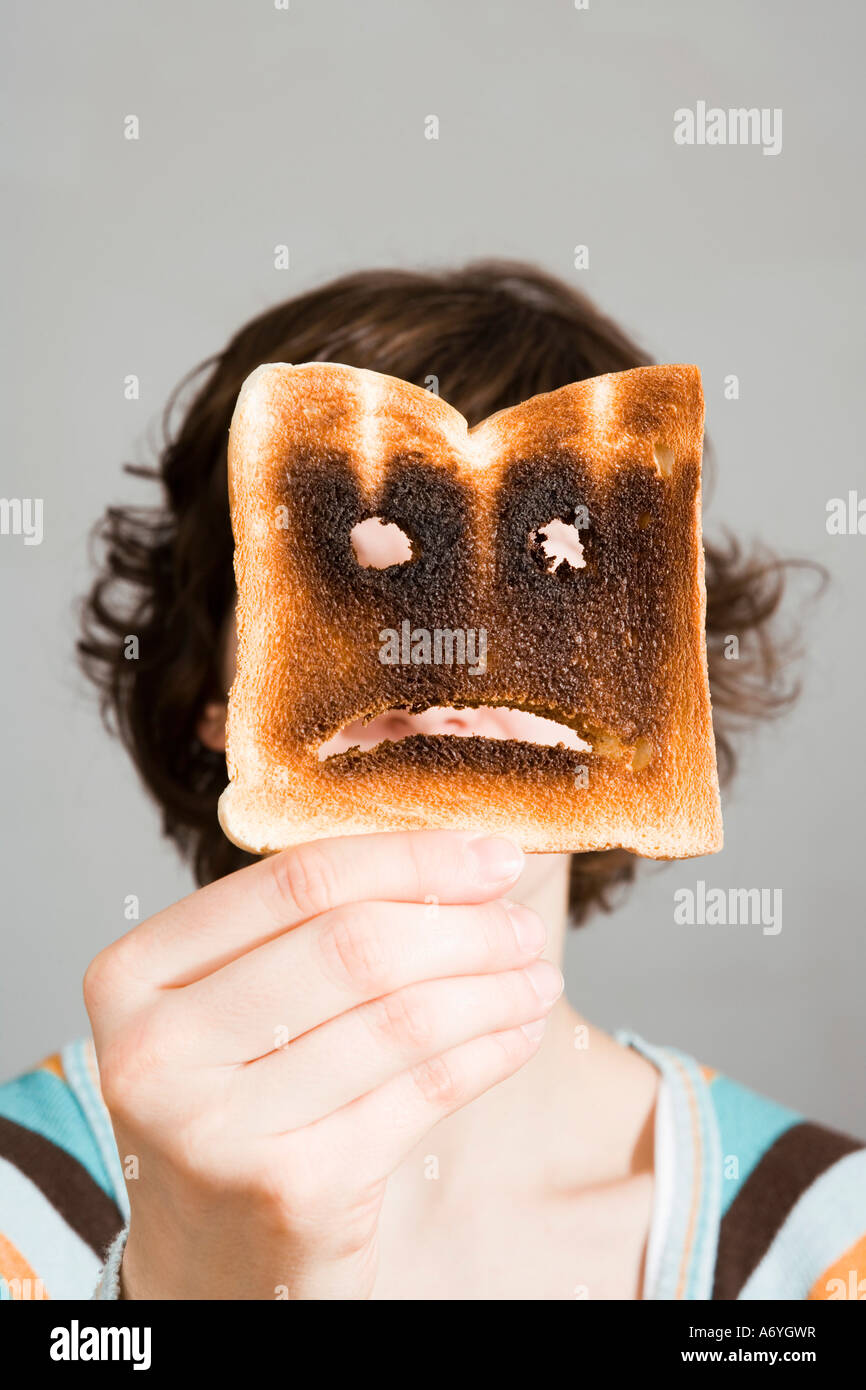 Woman holding burnt toast in front of face Stock Photo - Alamy