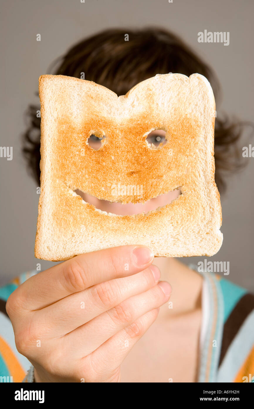 Woman holding toast in front of face Stock Photo - Alamy