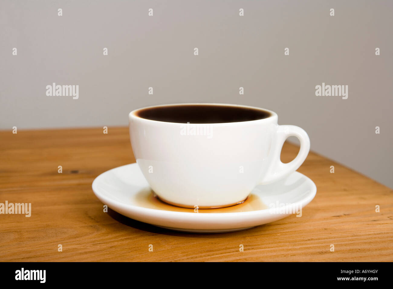 An overflowing coffee cup Stock Photo - Alamy