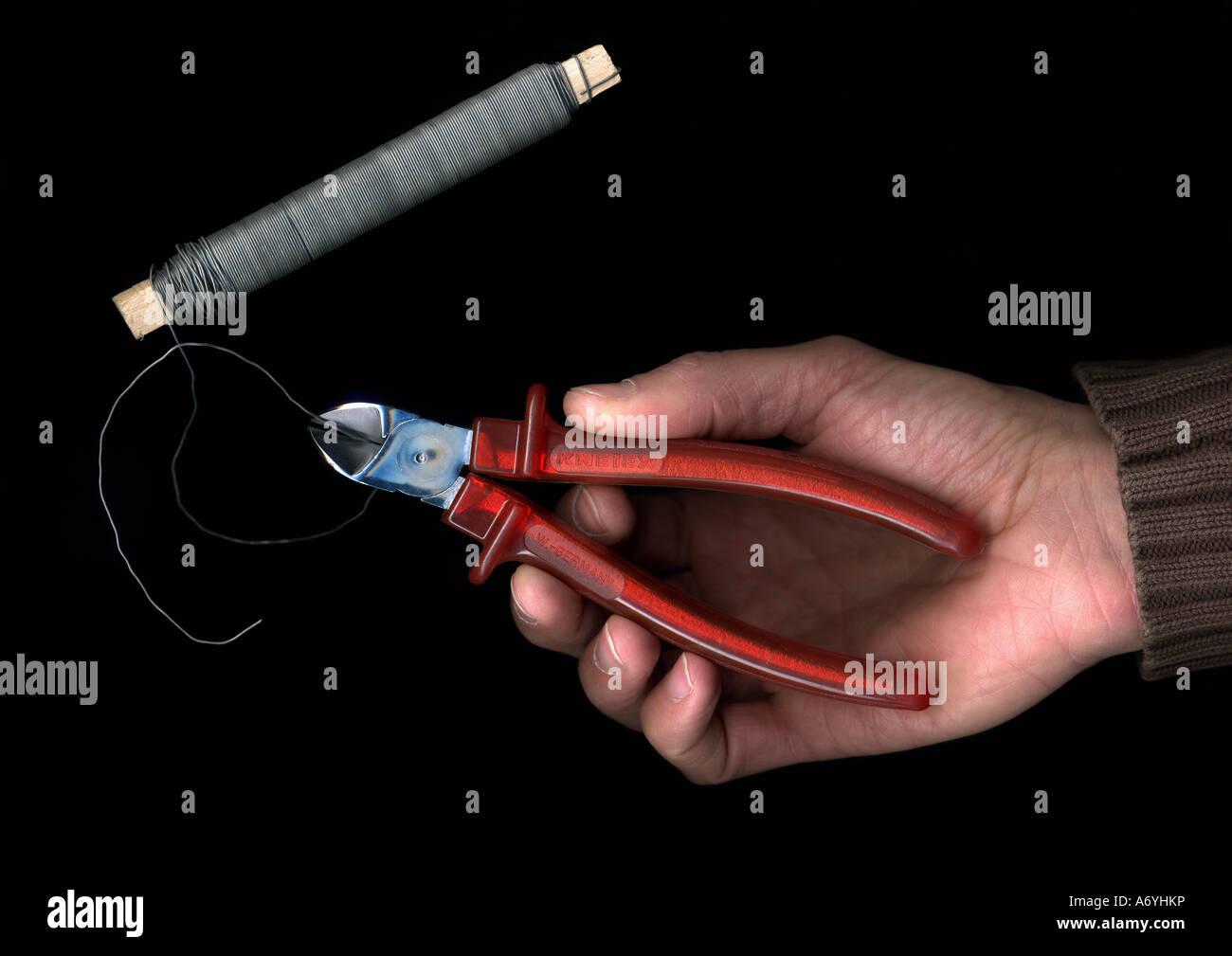 Man cutting wire with pliers Stock Photo - Alamy