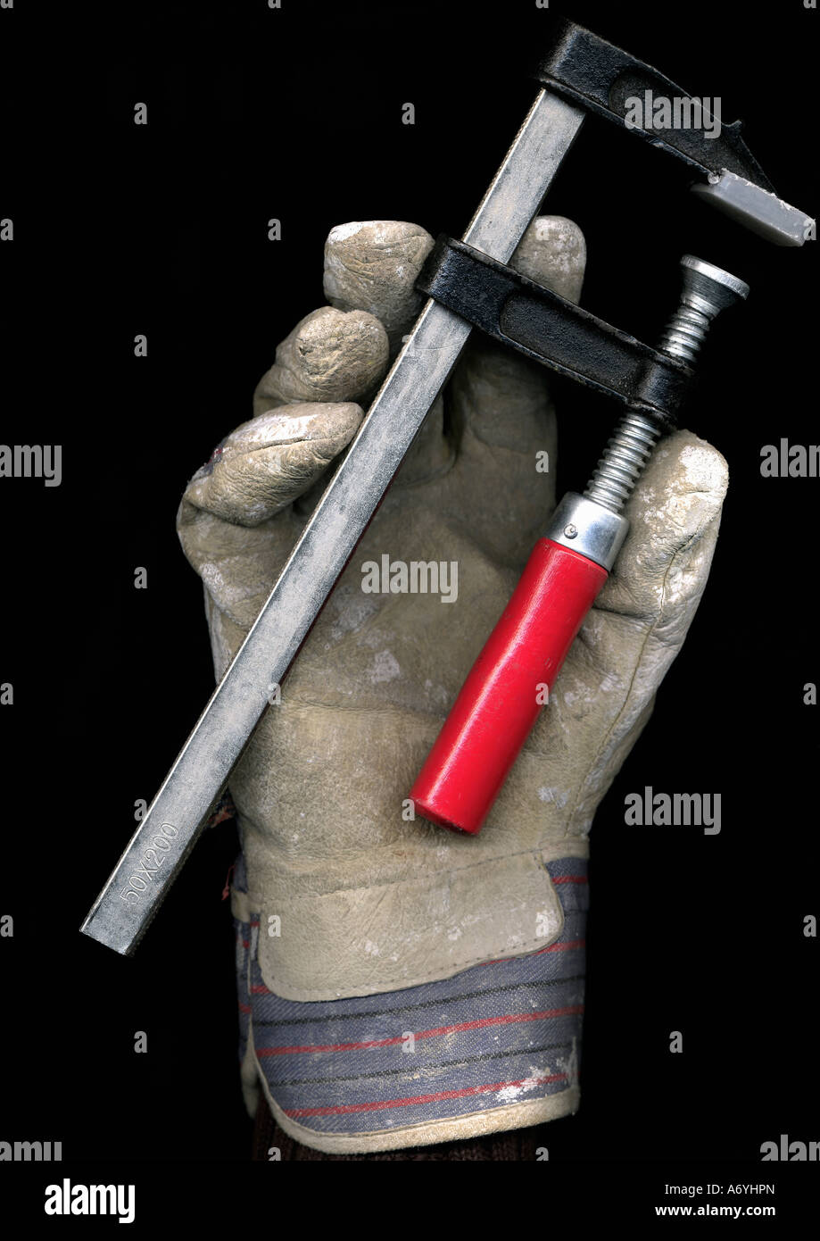 Person wearing a work glove and holding a clamp Stock Photo - Alamy